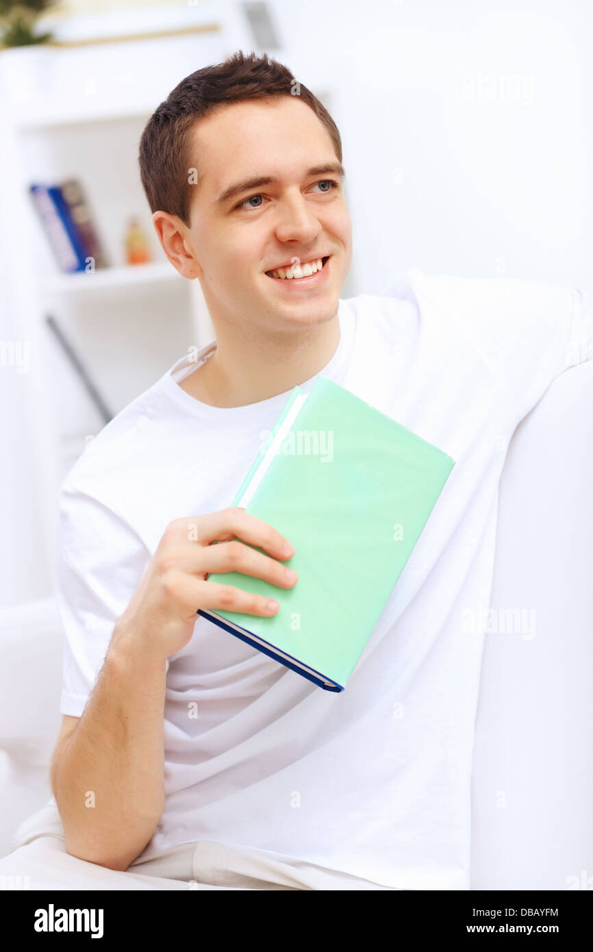Young man at home with a book Stock Photo - Alamy