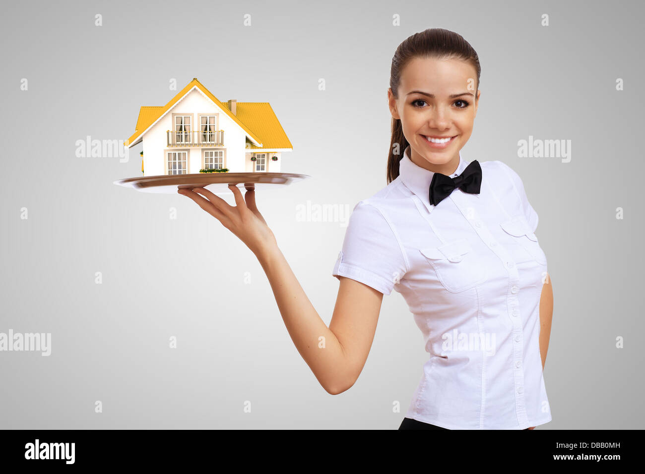 Waitress holding a tray with a house on it Stock Photo - Alamy