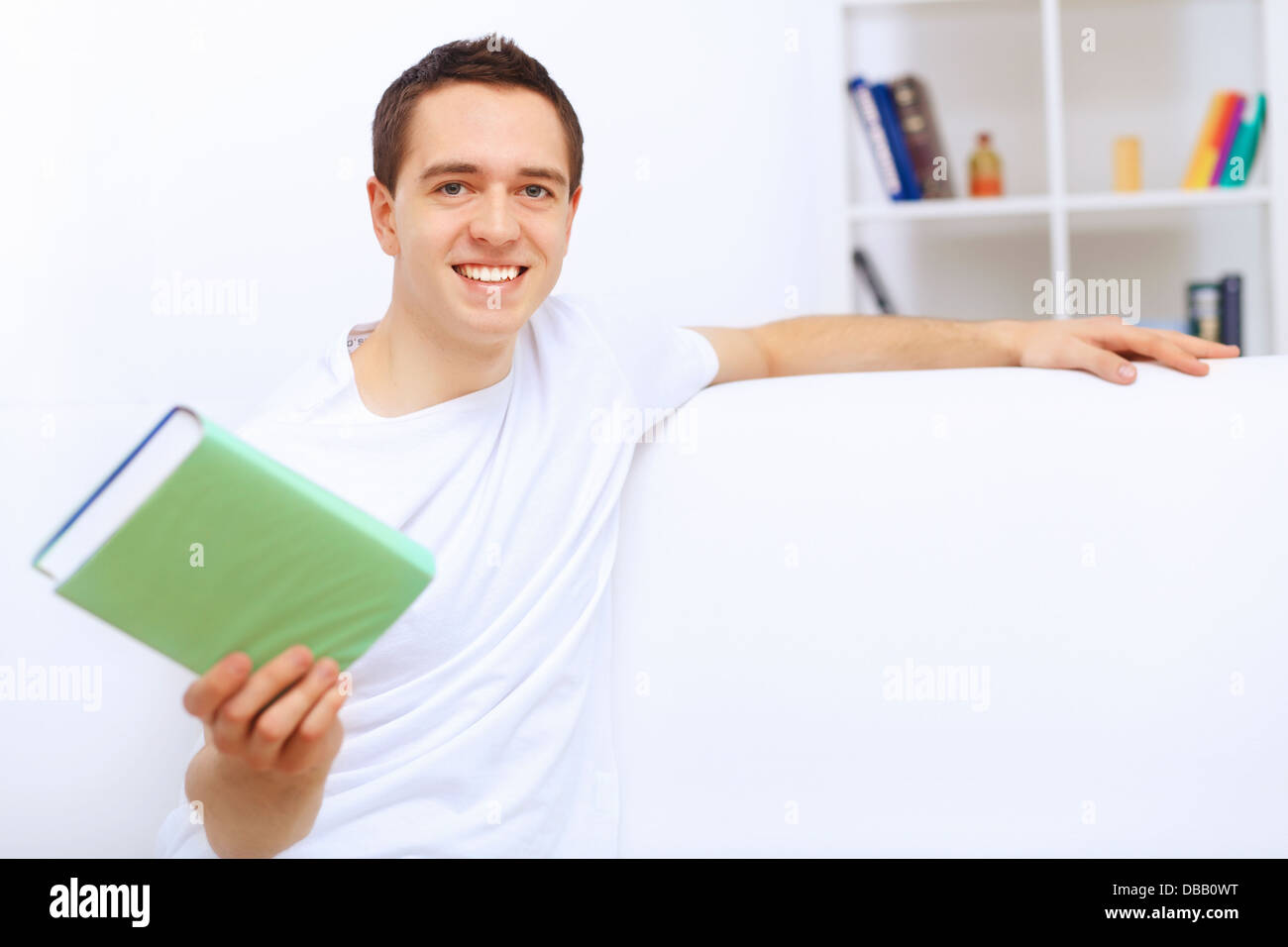 Young man at home with a book Stock Photo - Alamy