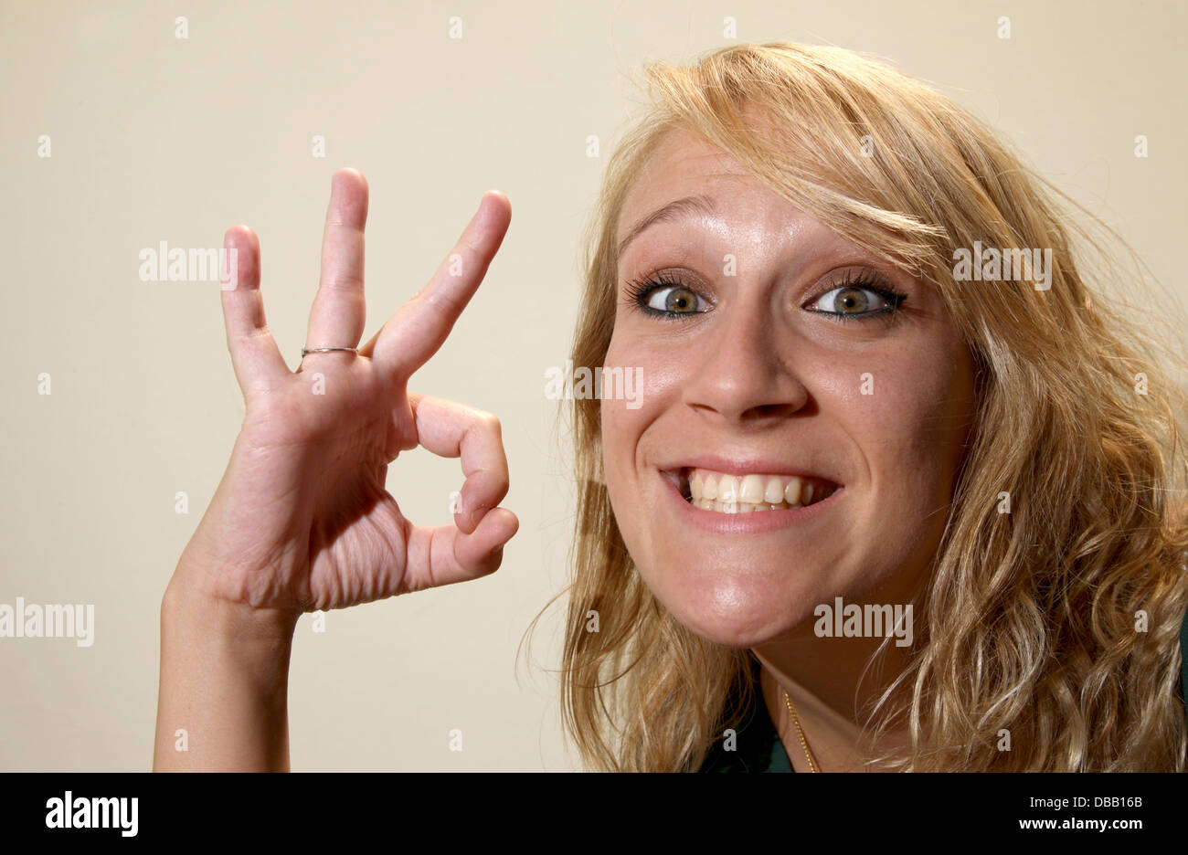 Young blond girl giving OK sign Stock Photo - Alamy