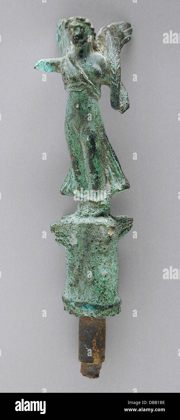 This staff finial features a winged goddess figurine, a symbol of ...
