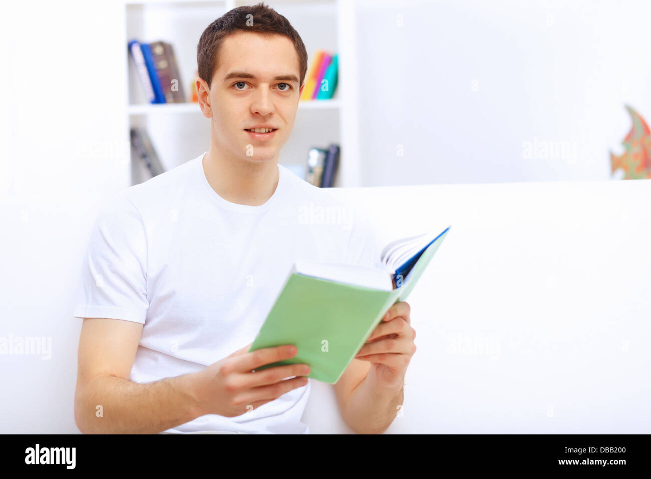 Young man at home with a book Stock Photo - Alamy