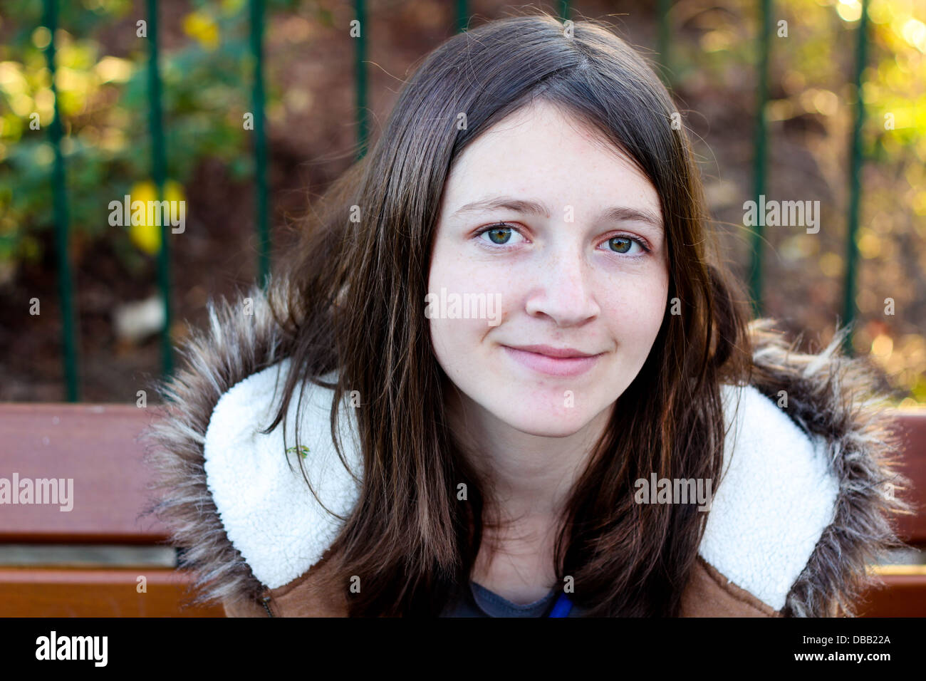 Portrait Of A Young Brunette Girl Smiling While Sitting Outside On A