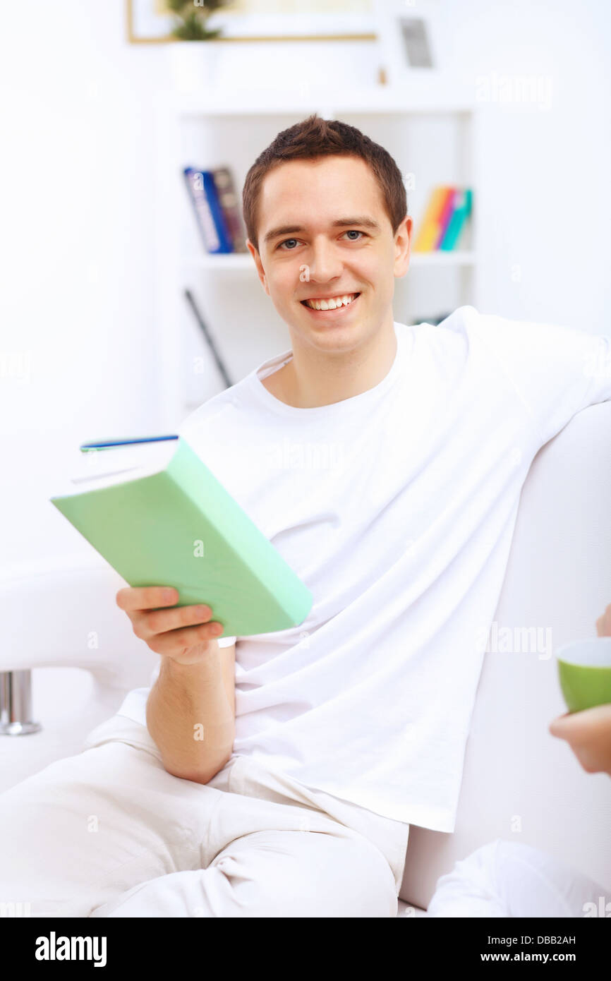 Young man at home with a book Stock Photo - Alamy