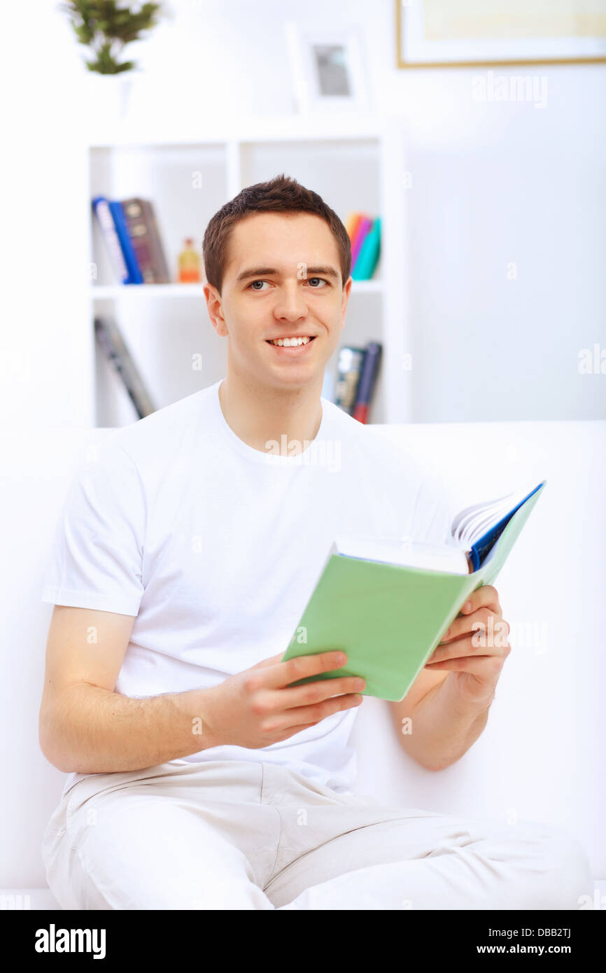 Young man at home with a book Stock Photo - Alamy