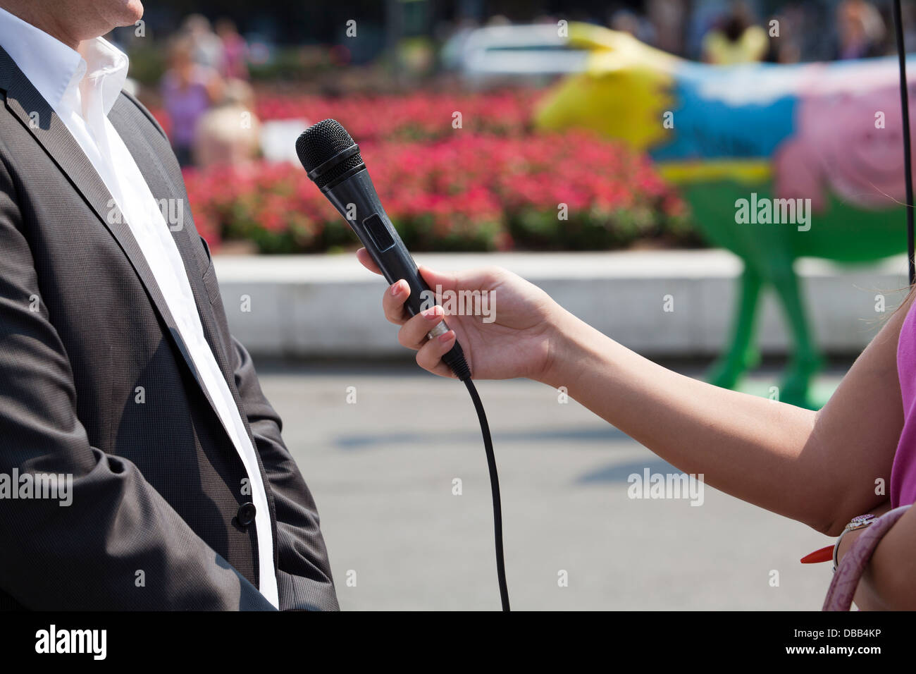 A journalist is making an interview with a microphone Stock Photo - Alamy