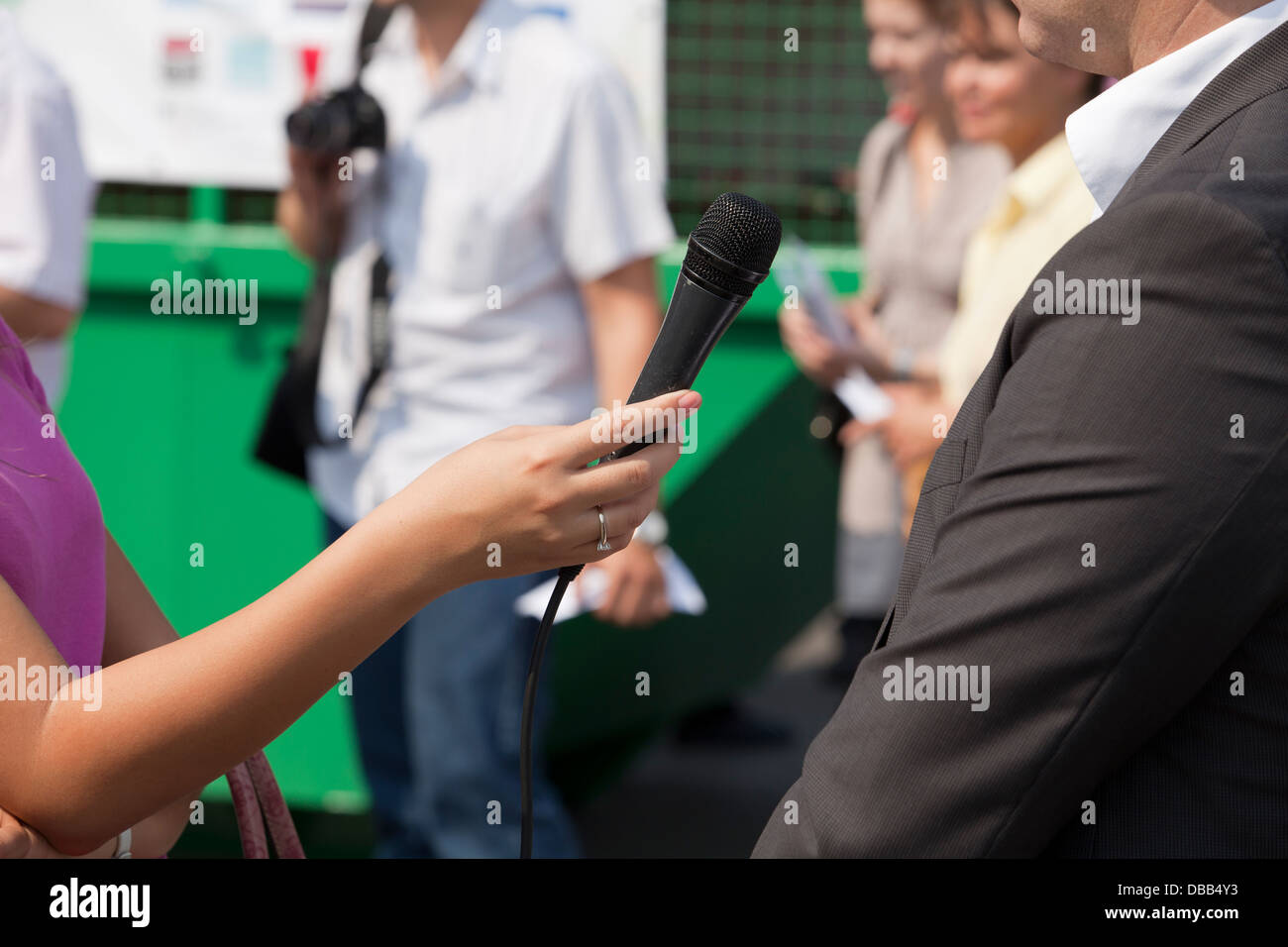 A journalist is making an interview with a microphone Stock Photo - Alamy