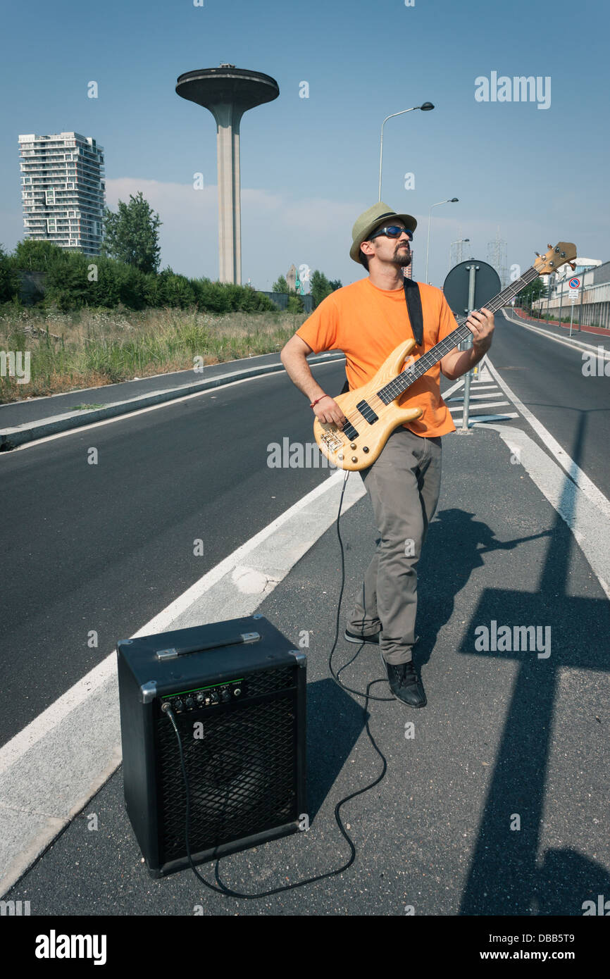 Young musician playing bass guitar in the street Stock Photo - Alamy