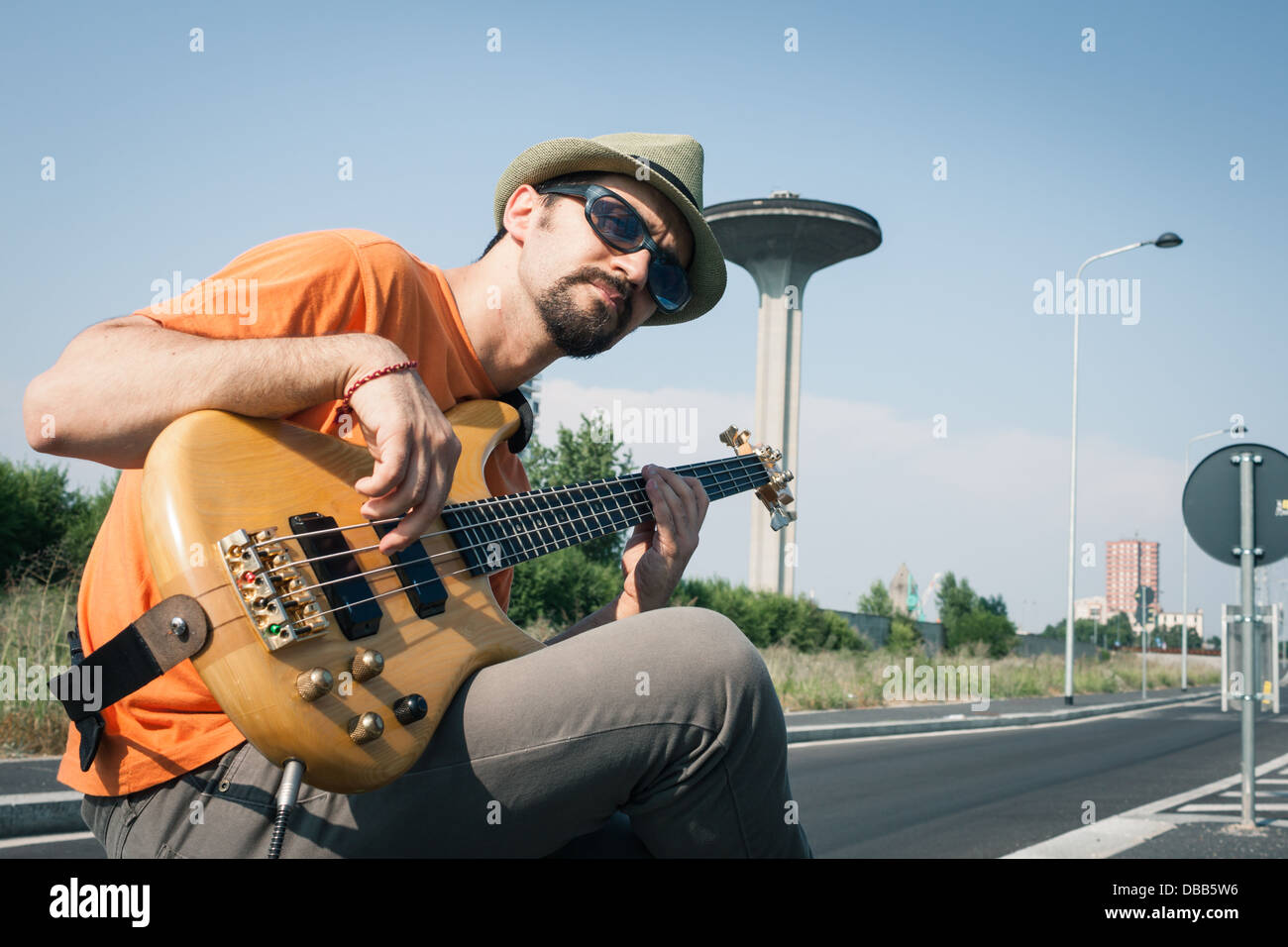 Young musician playing bass guitar in the street Stock Photo - Alamy