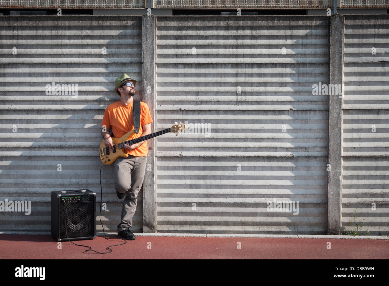 Young musician playing bass guitar in the street Stock Photo - Alamy