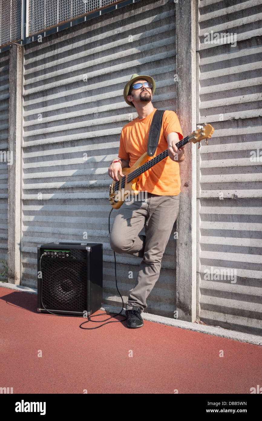 Young musician playing bass guitar in the street Stock Photo - Alamy