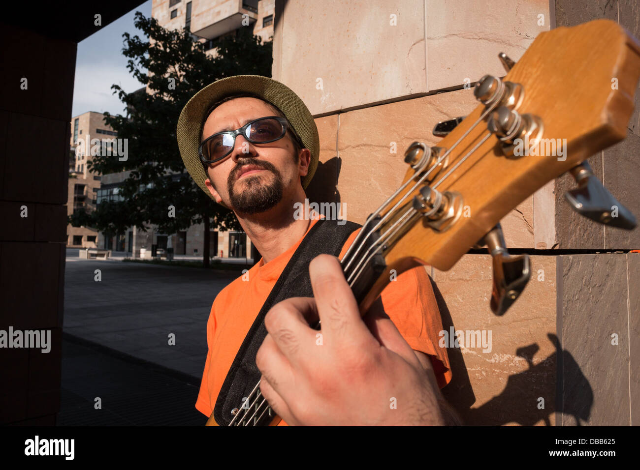 Young musician playing bass guitar in the street Stock Photo - Alamy