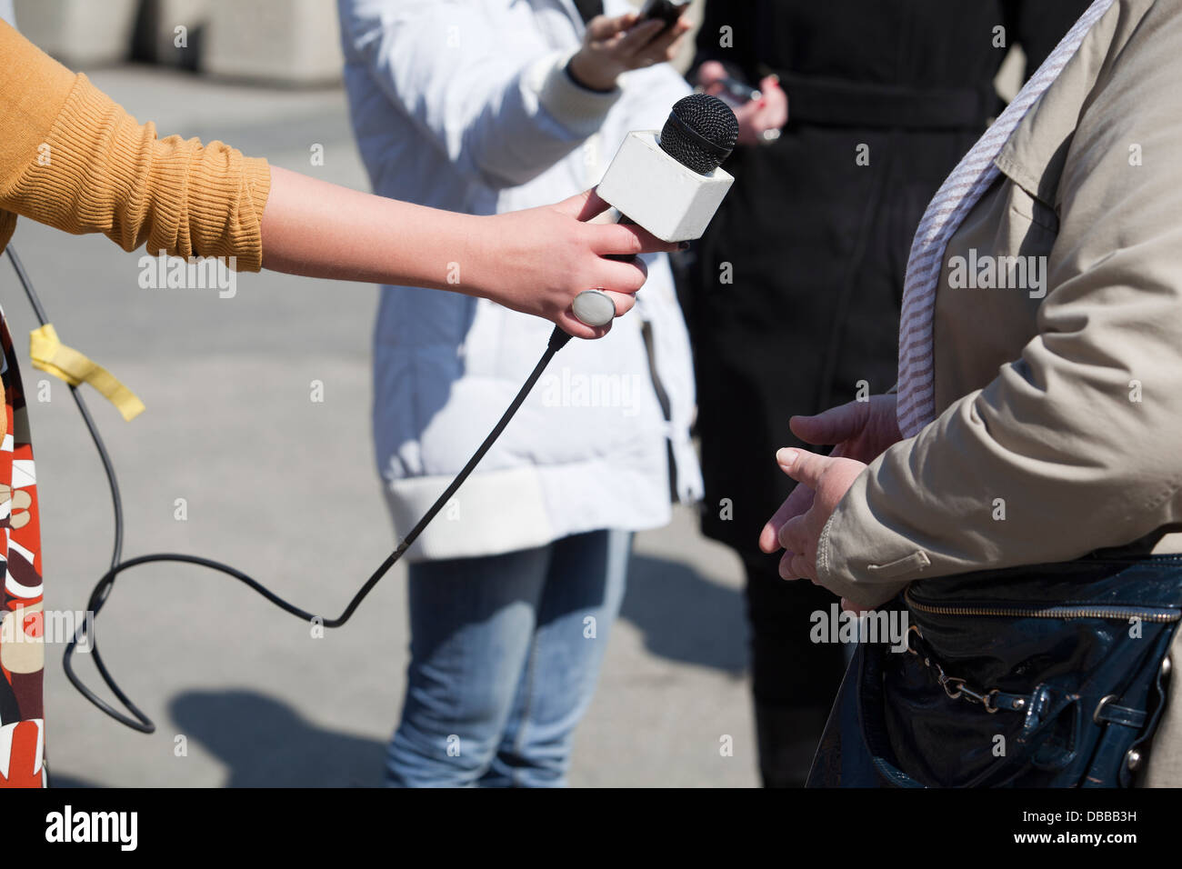 A journalist is making an interview with a microphone Stock Photo - Alamy