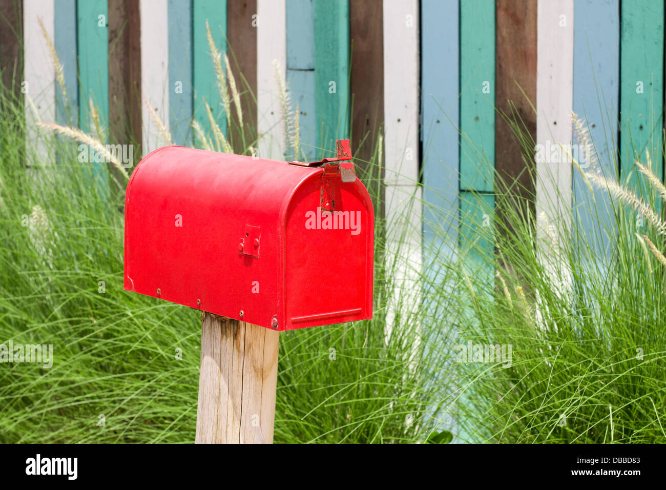 A plain Red Mailbox in front of some bushes Stock Photo - Alamy