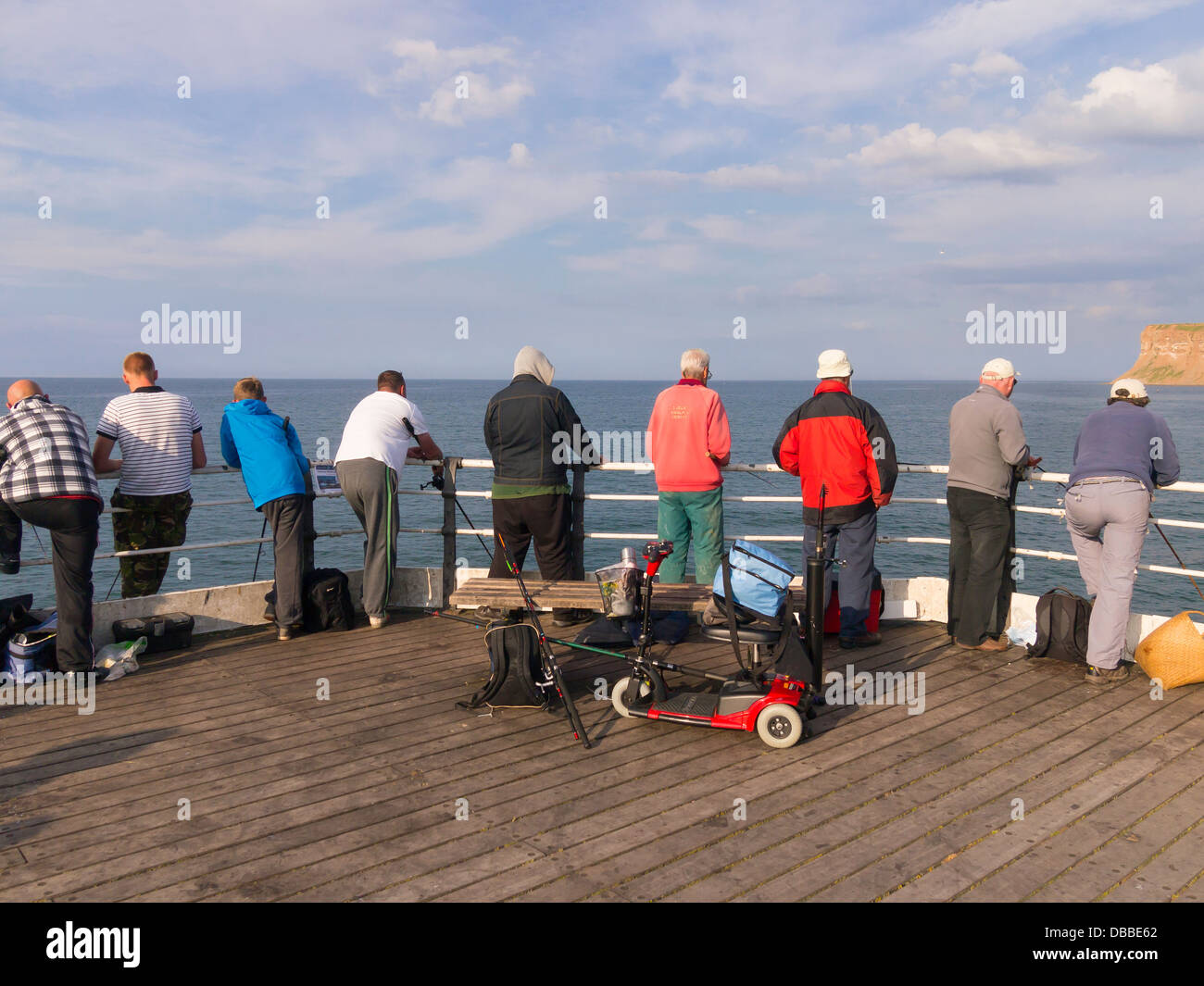 Anglers fishing from the end of Saltburn Pier at high tide on a warm ...