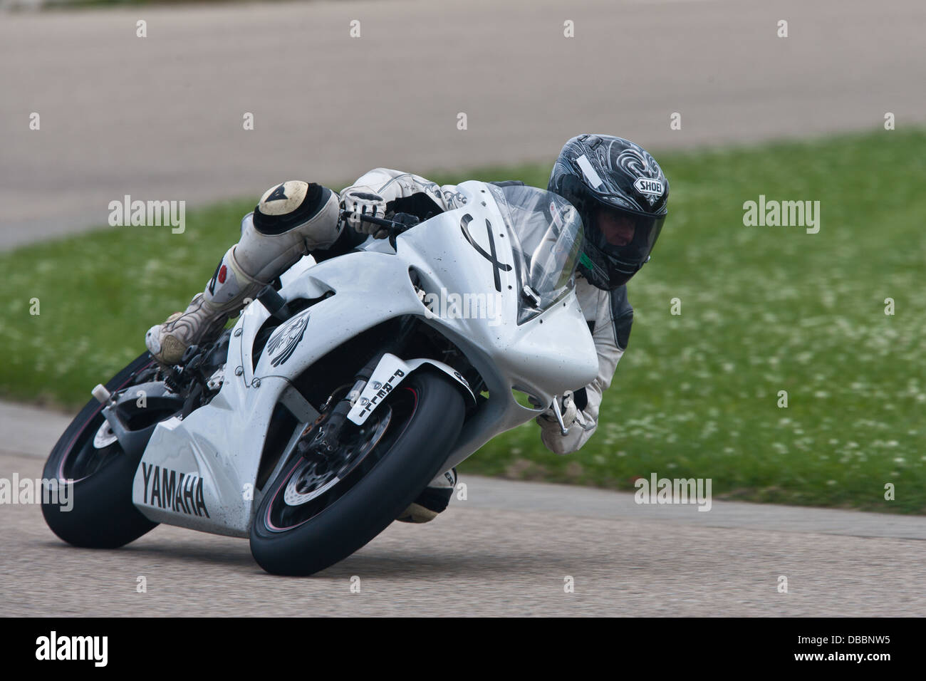Motorcycle racer on track in left turn Stock Photo - Alamy