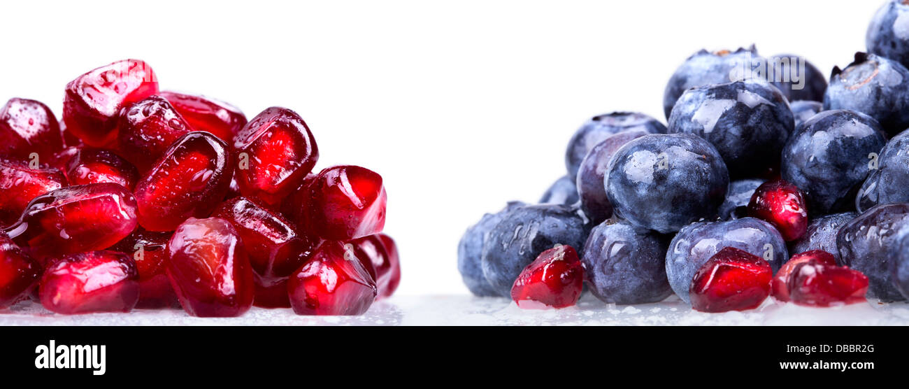 Ripe pomegranate and blue berrie fruit macro background Stock Photo - Alamy