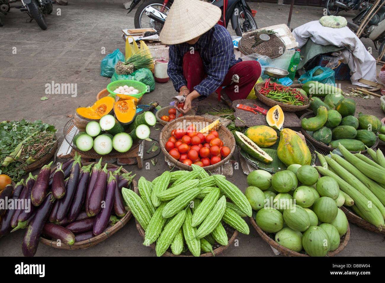 Woman selling fresh vegetables and other foods at market in Hoi An ...