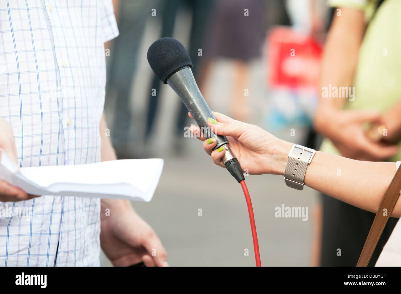 A journalist is making an interview with a microphone Stock Photo - Alamy