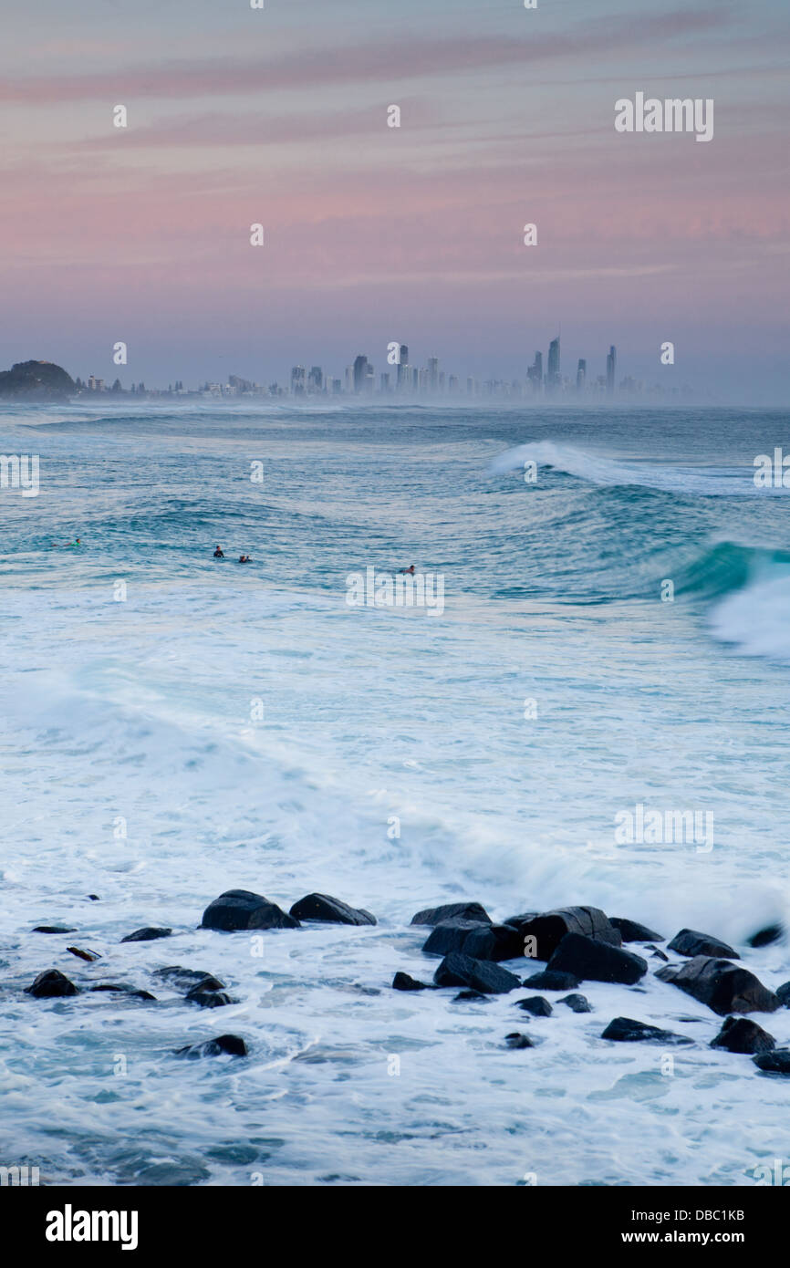 Early morning surfers at Burley Heads with skyline of Surfers Paradise ...