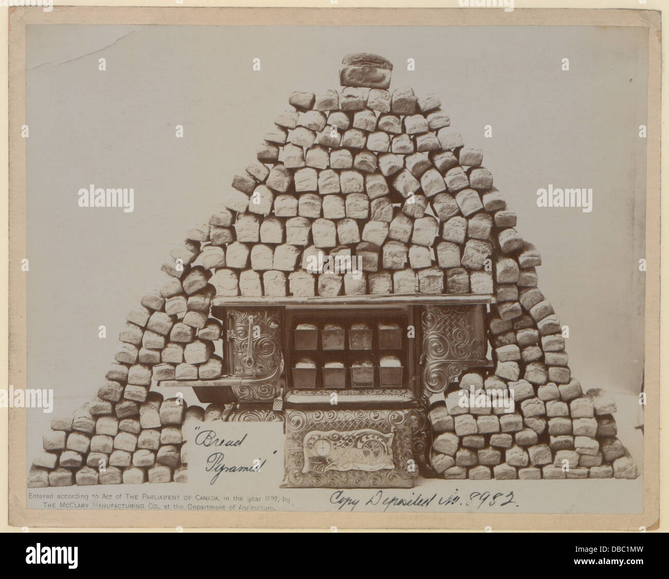 A pyramid made of bread loaves is shown in this historical photograph ...