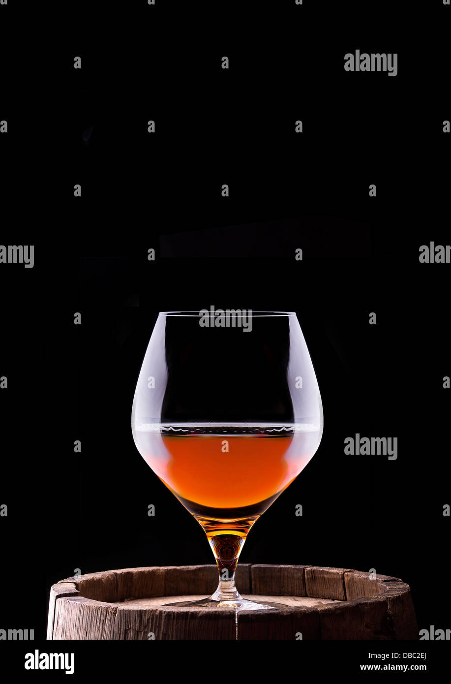 Cognac or brandy on a wooden vintage barrel with black background Stock ...