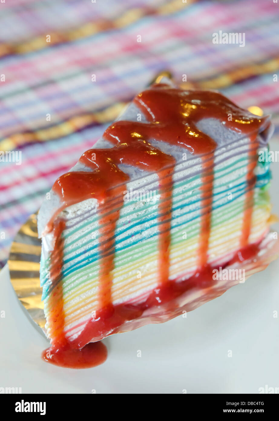 colorful crepe cake on white plate with strawberry syrup Stock Photo ...