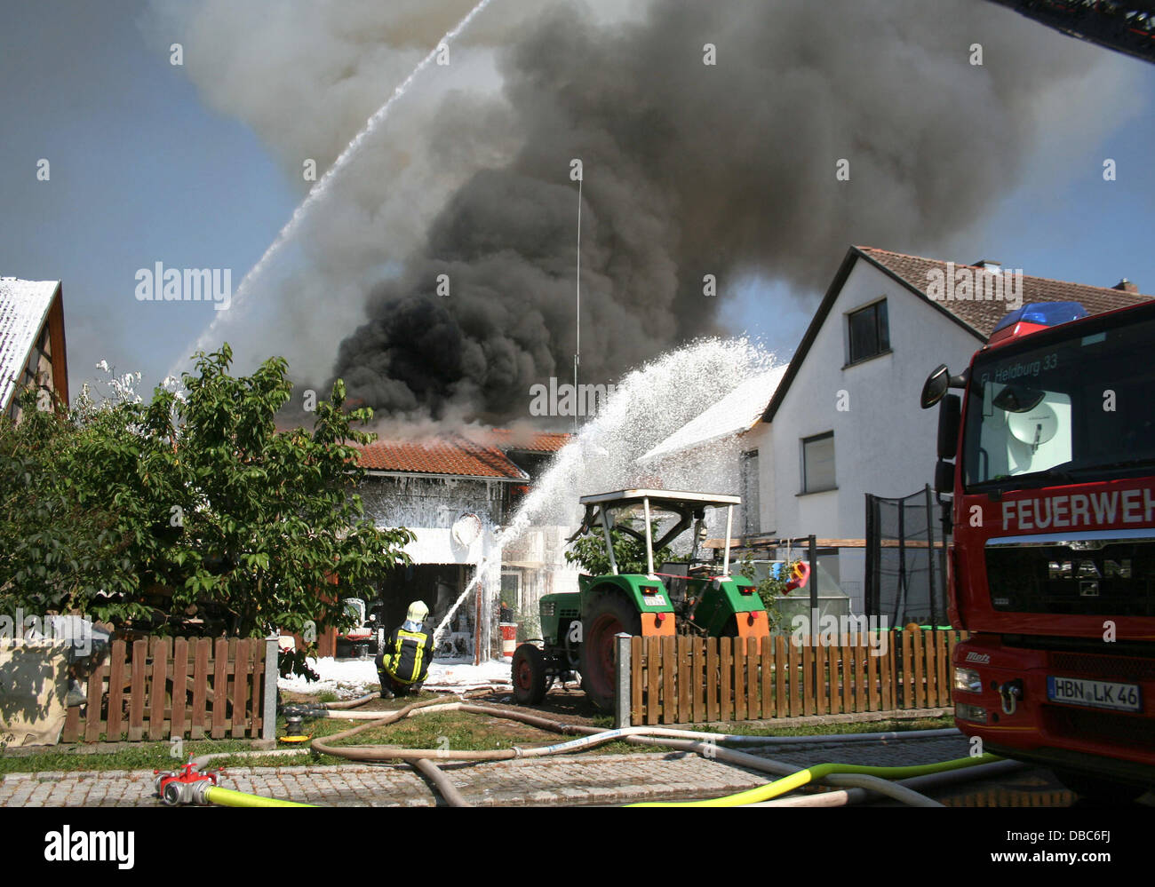 Fire fighters try to extinguish a fire in Straufhain, Germany, 27 July ...