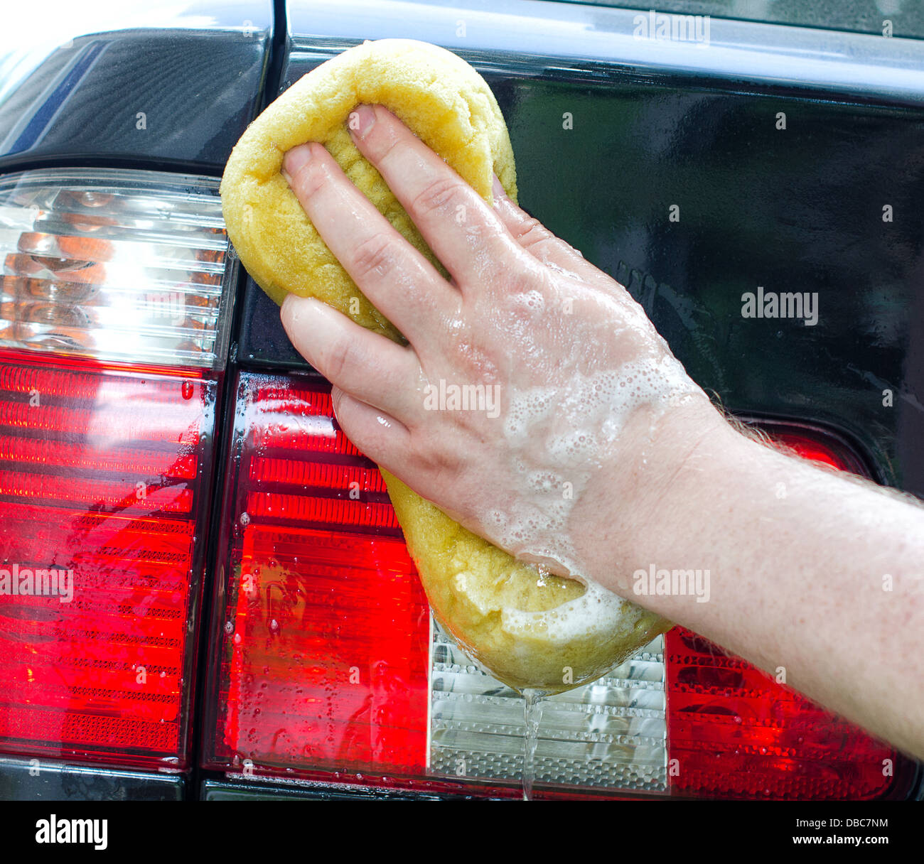 Male hand washing car with yellow sponge Stock Photo - Alamy