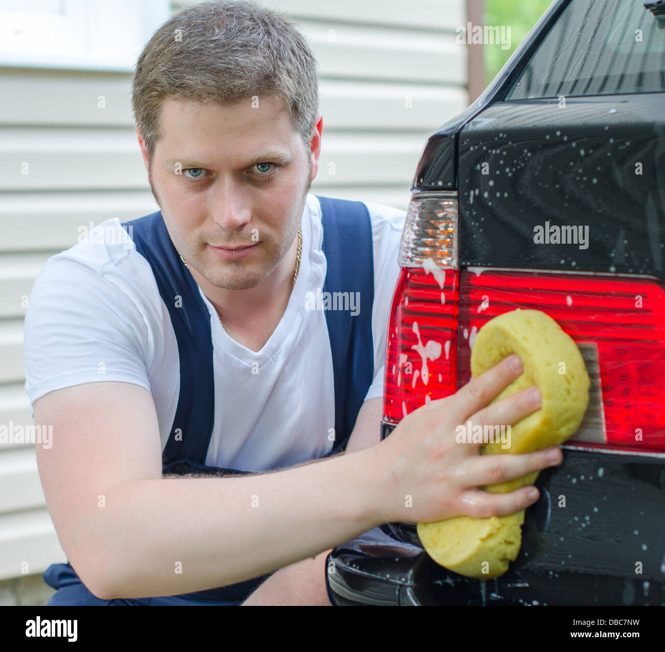 Young worker washing car with yellow sponge Stock Photo - Alamy