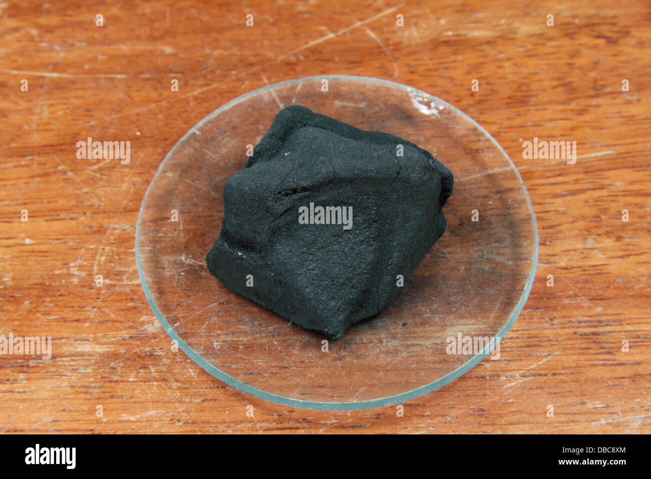 A single coke piece on a watch glass, as used in a UK high school Stock ...