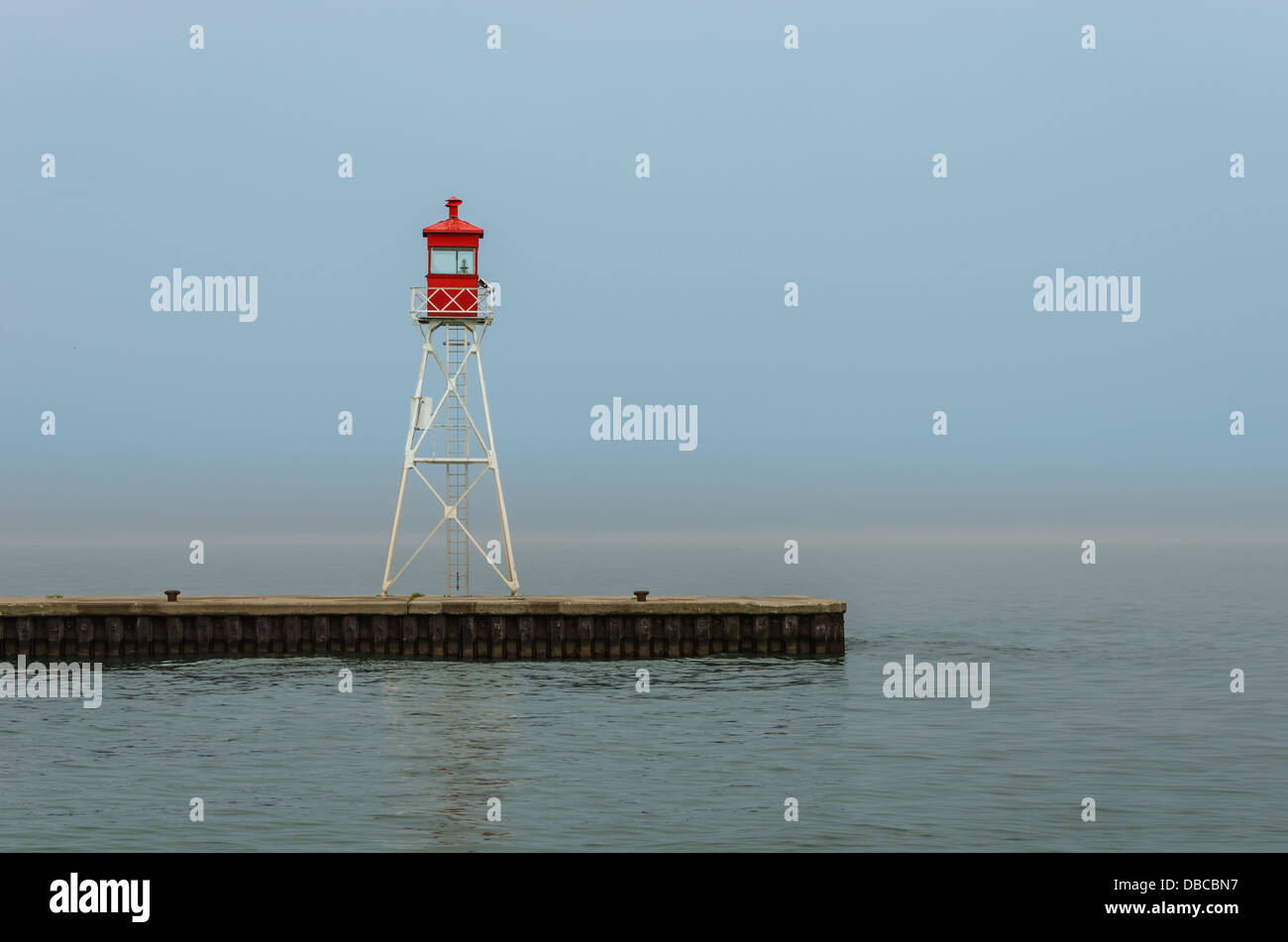 A small red Lighthouse at the end of a dock Stock Photo - Alamy