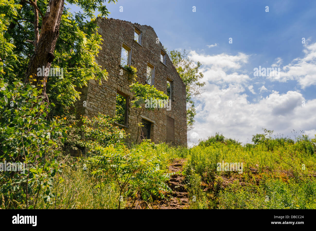 An abandoned empty shell of an old House on the bank of a river Stock ...