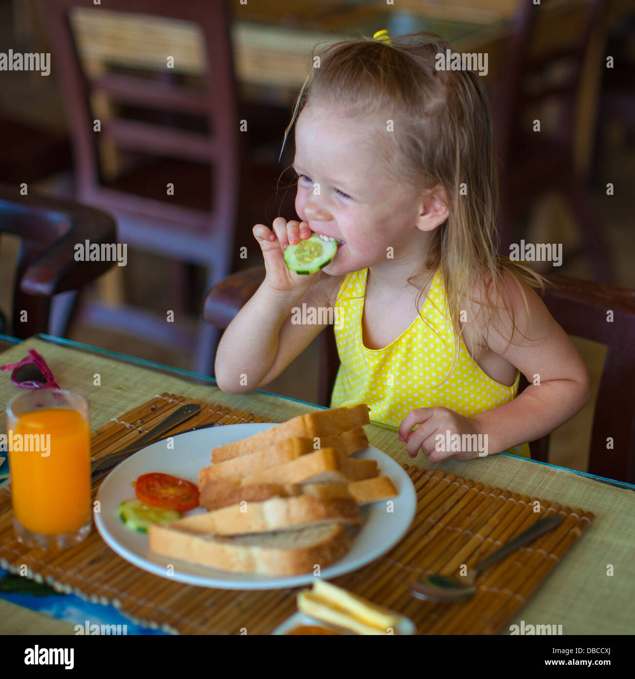 Cute little girl having breakfast at resort restaurant Stock Photo - Alamy