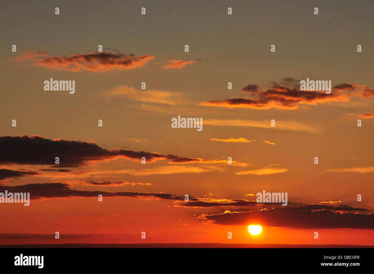 Setting sun with clouds in the sky Stock Photo - Alamy