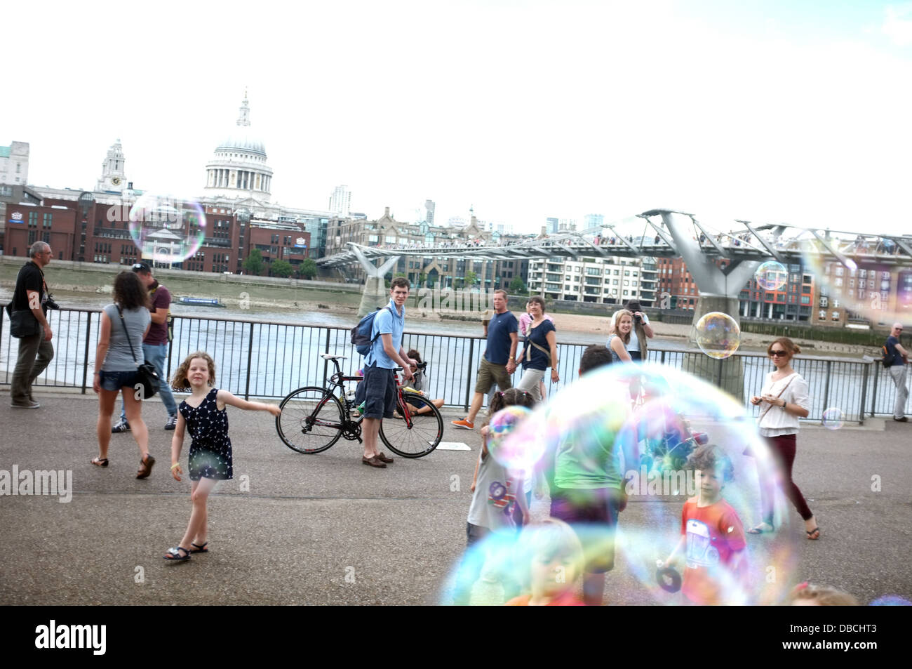 Kids enjoy bubble chase Stock Photo - Alamy
