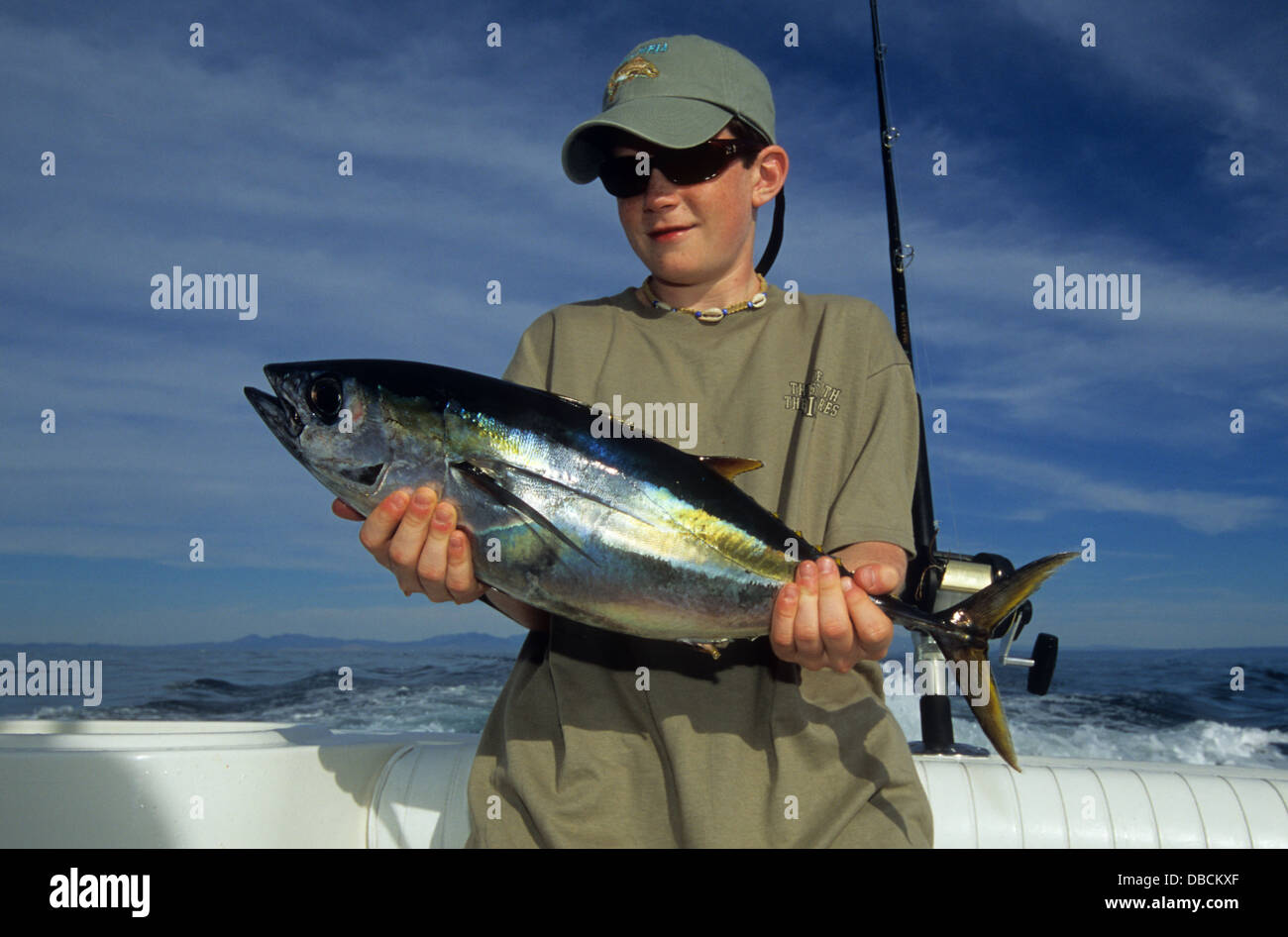 Young boy with a yellowfin tuna (Thunnus albacares) caught trolling ...