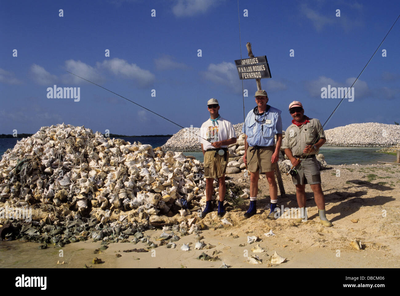 Fly fishermen standing near piles of bleached conch shells at Los ...