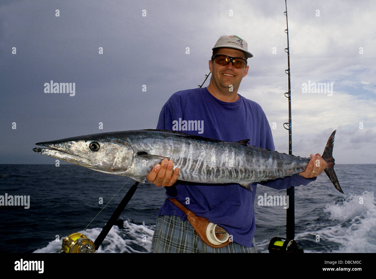 Man holding a wahoo (Acanthocybium solandri) caught while deep sea ...