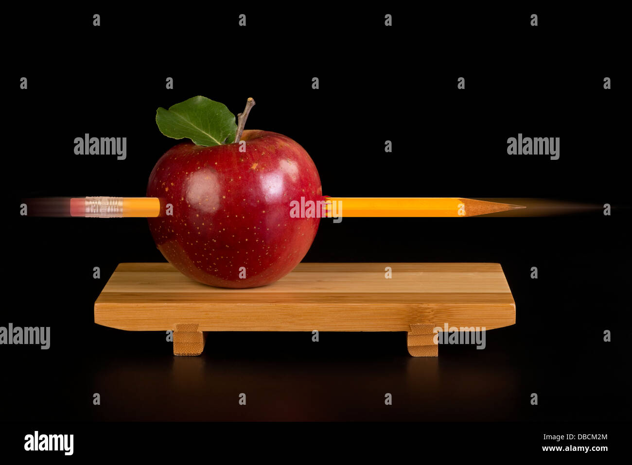 Pencil through red apple Stock Photo - Alamy