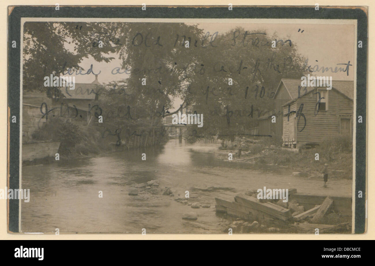 This photograph depicts a peaceful scene of an old mill stream ...