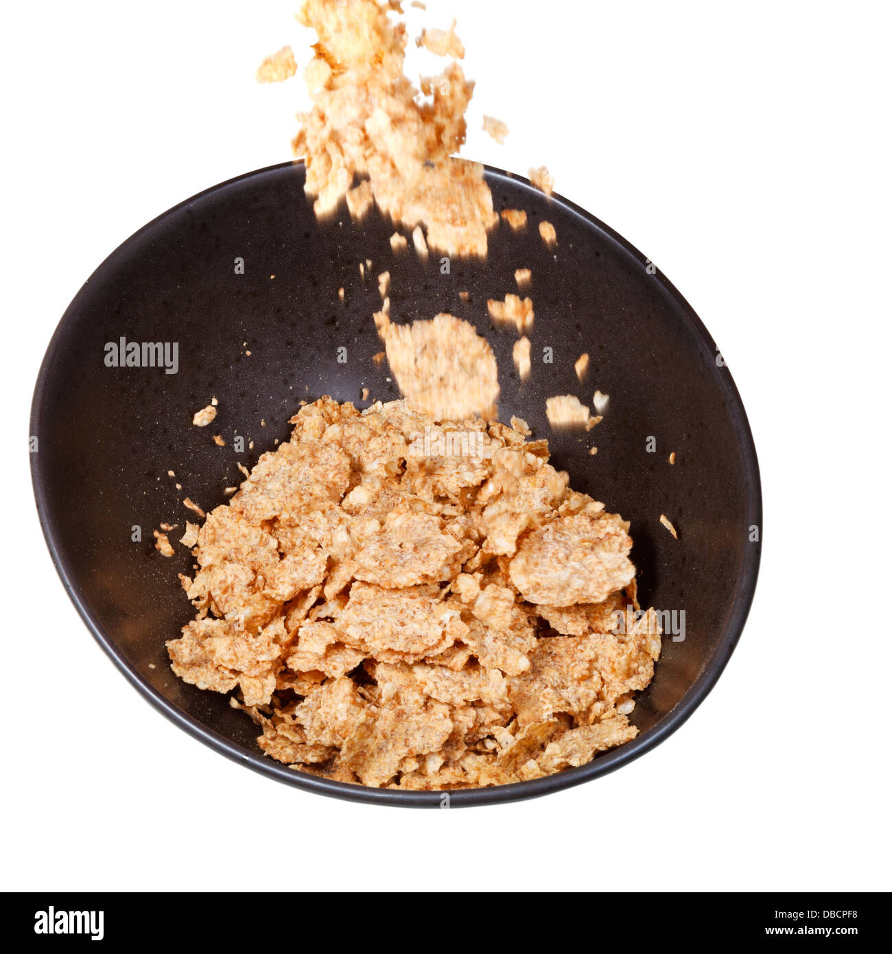 poured corn flakes in dark bowl isolated on white background Stock ...