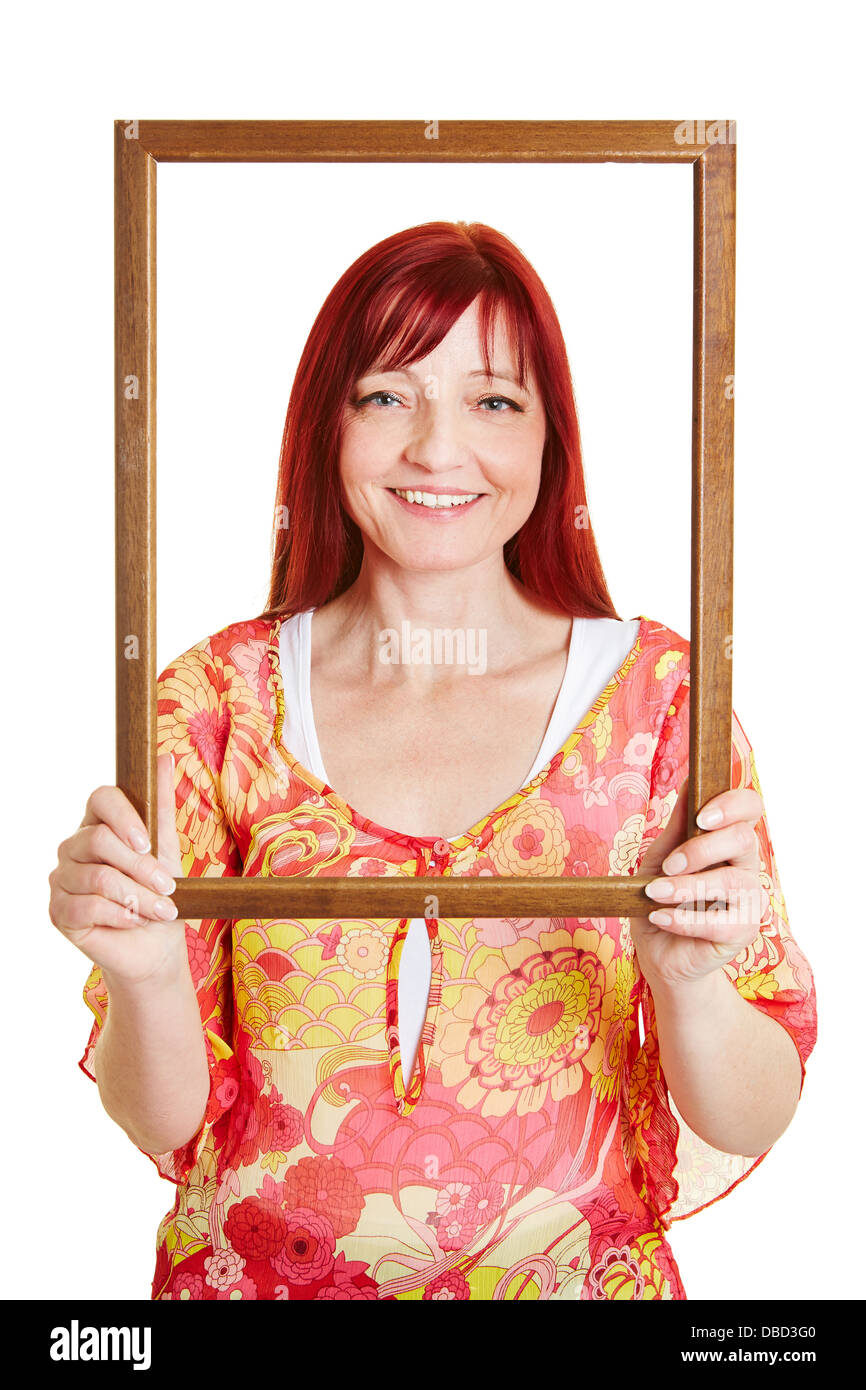 Woman looking through empty wooden picture frame Stock Photo - Alamy