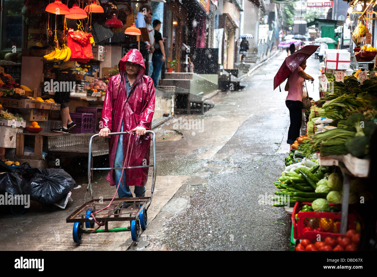 Man pushes metal trolley in the rain, Graham Street wet market, Hong ...