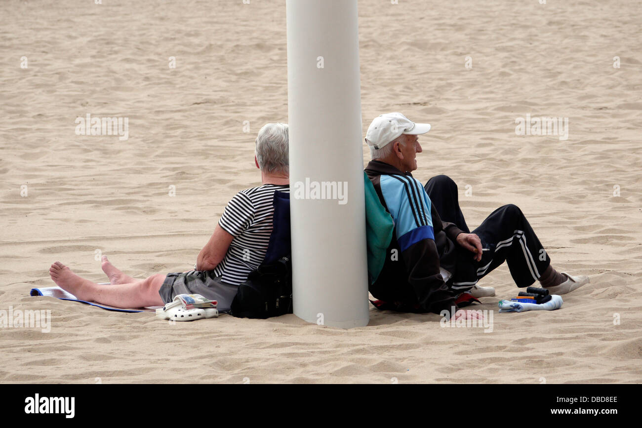 Retired couple relaxing on the beach Stock Photo - Alamy