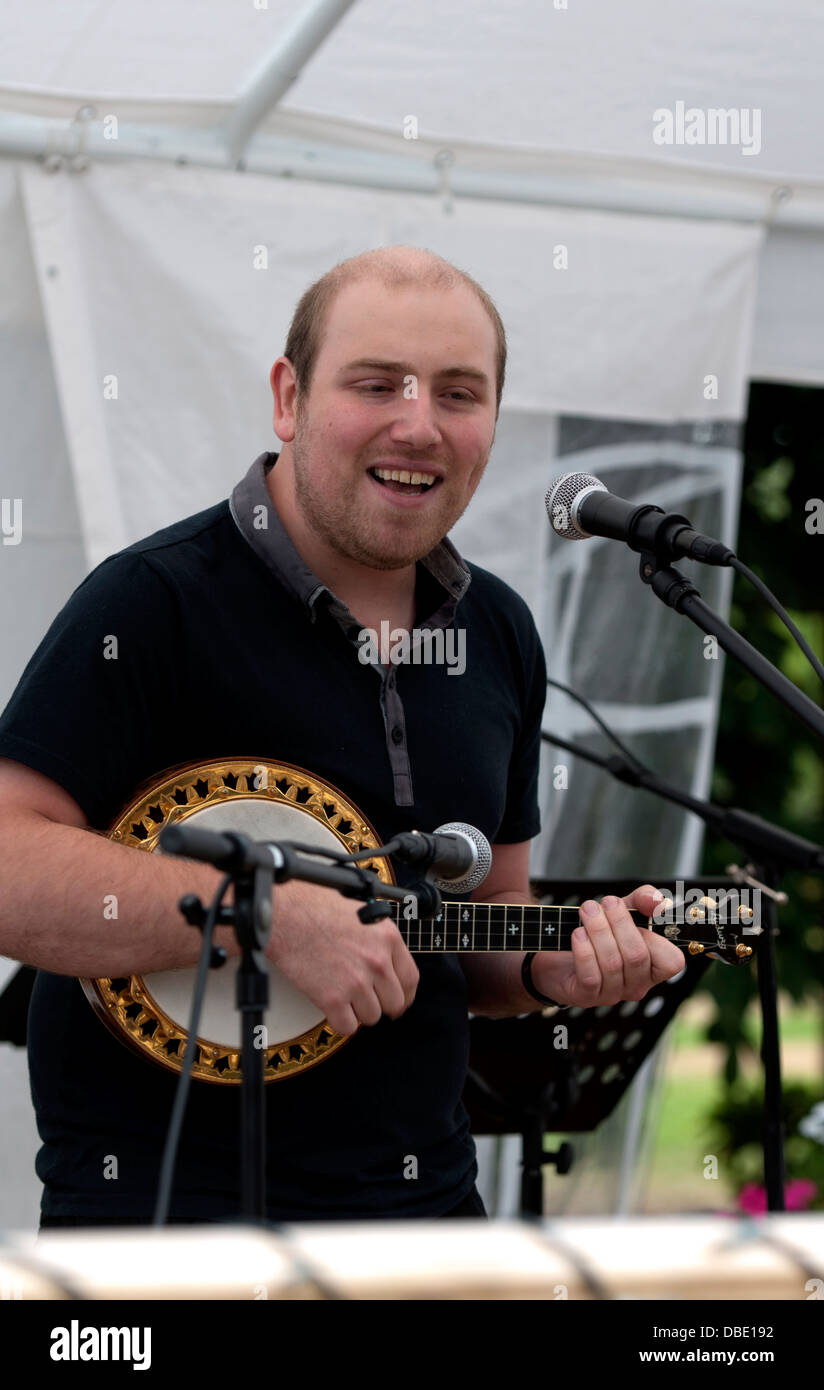 Matt Richards singing and playing a banjo ukulele Stock Photo - Alamy