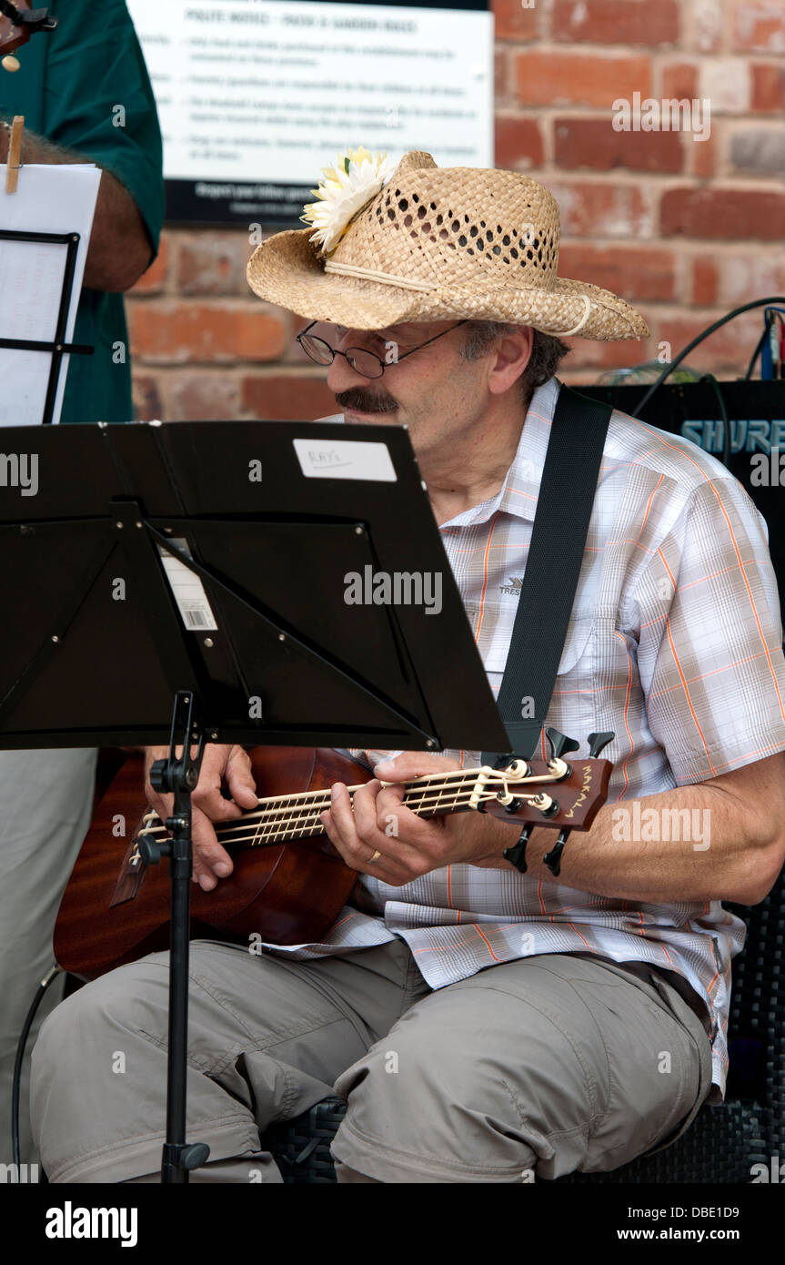 Man playing bass ukulele Stock Photo - Alamy
