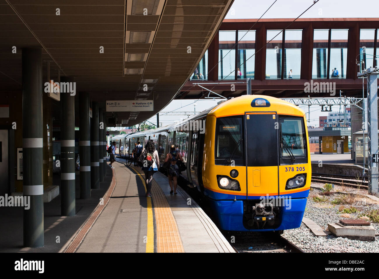 Passengers boarding Overground train at Stratford railway station ...