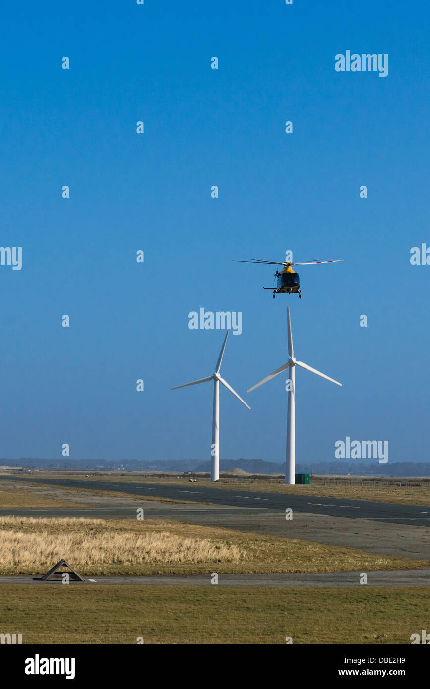 Helicopter flying near wind turbines Stock Photo - Alamy
