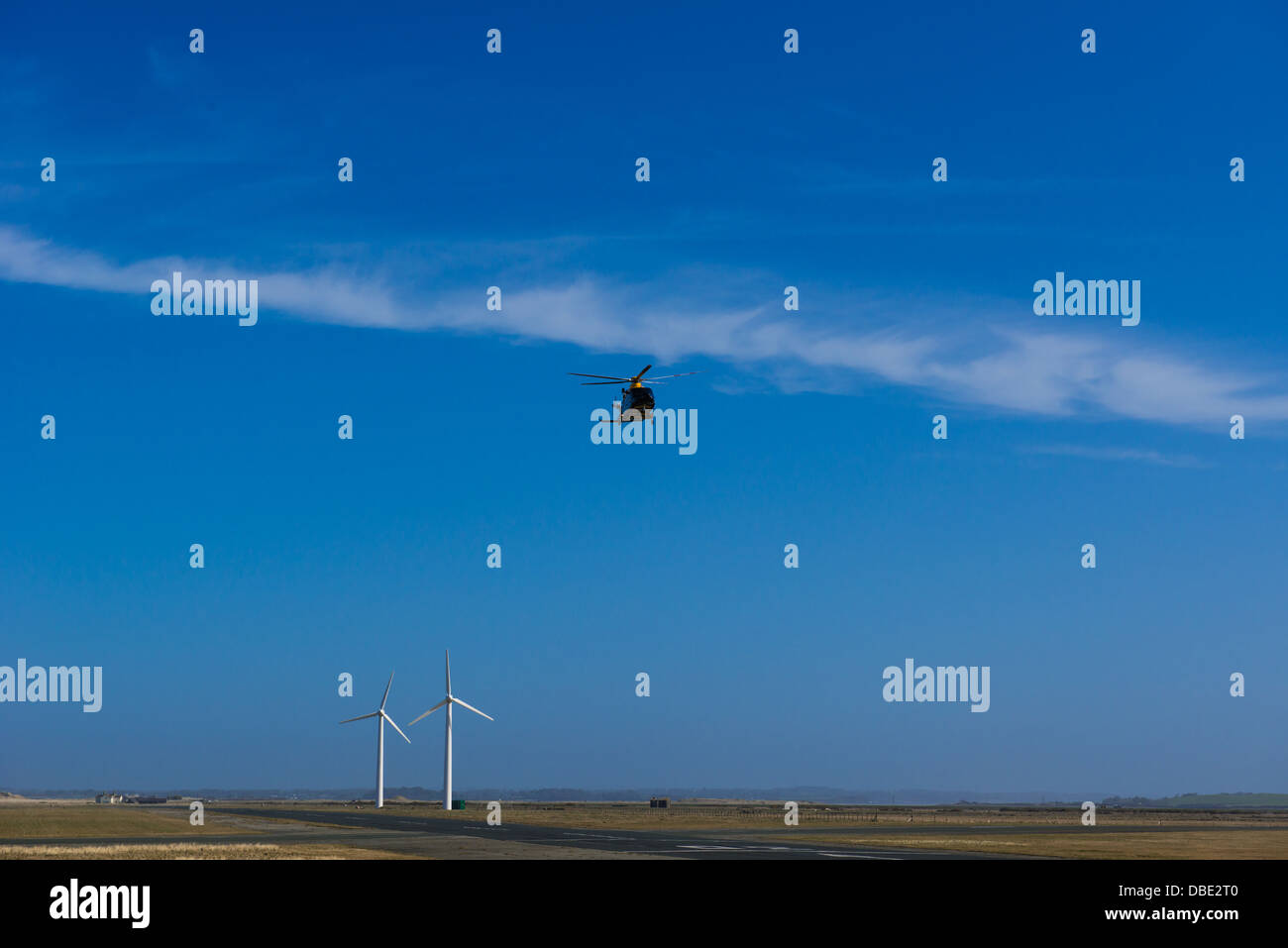 Helicopter flying over wind power turbines Stock Photo - Alamy
